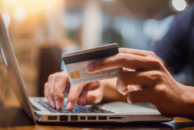 Premium Photo | Man holding credit card and using laptop Premium Photo | Man holding credit card and using laptop