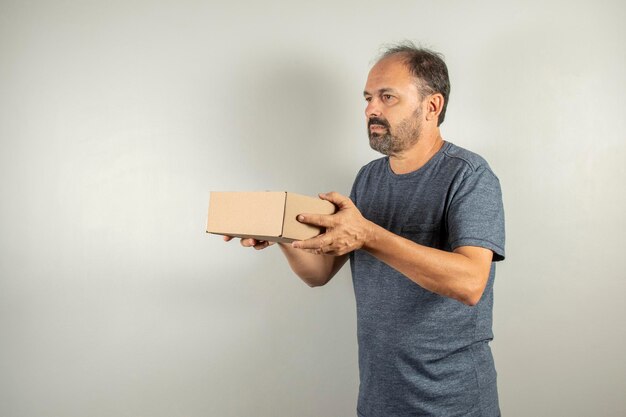 Premium Photo | Merchandise delivery man with a box in hand simulating ... Premium Photo | Merchandise delivery man with a box in hand simulating ...