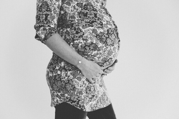 Premium Photo Midsection Of Pregnant Woman Standing Against Wall