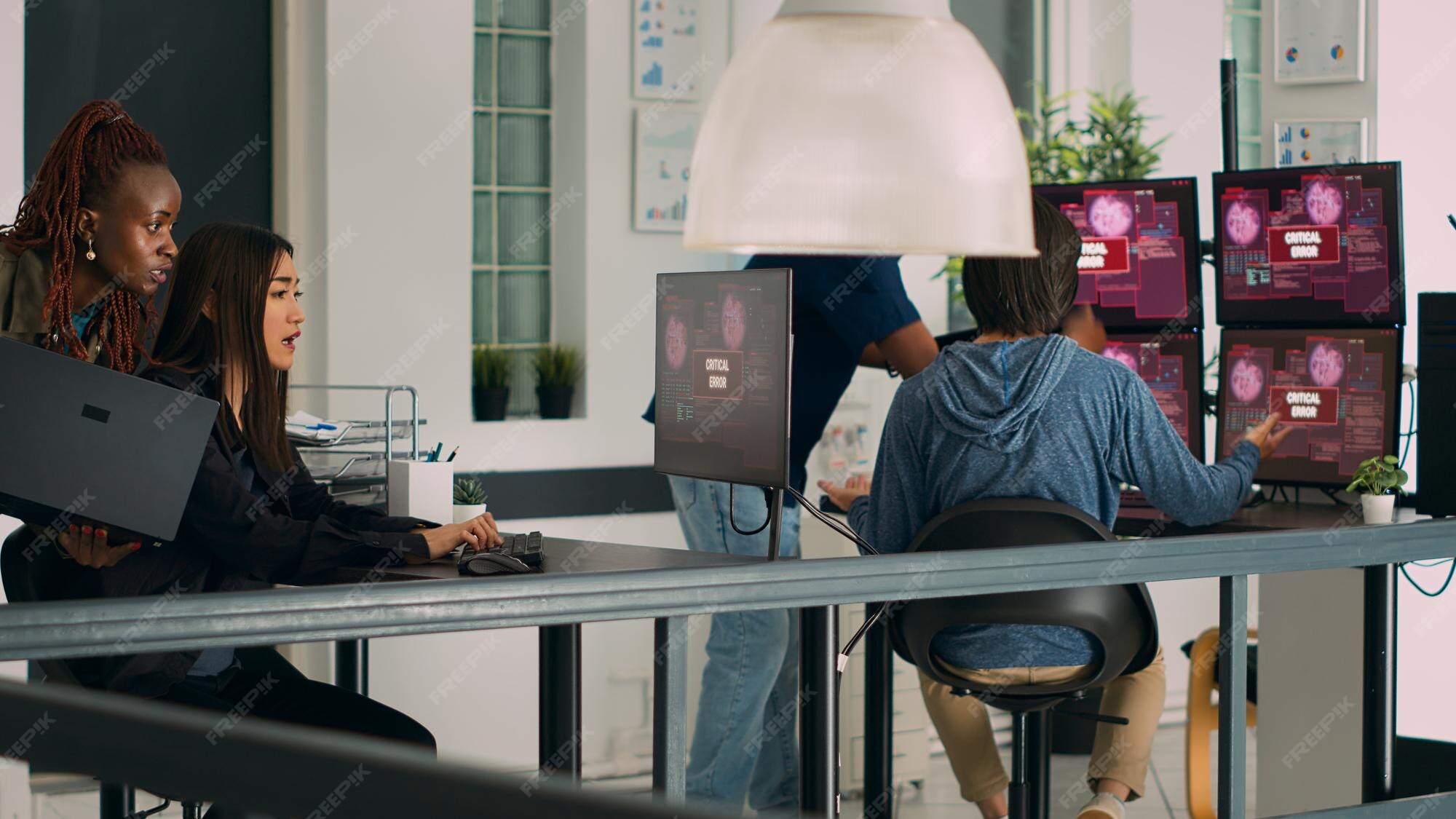 Premium Photo | Multiethnic team of coders encountering system error message on computer, trying ...