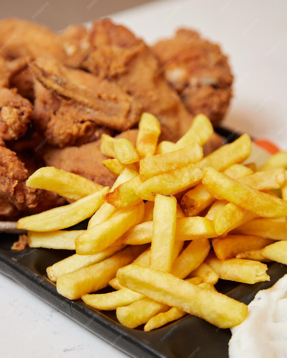 Premium Photo A Plate Of Fried Chicken And Fries With A Side Of Fries
