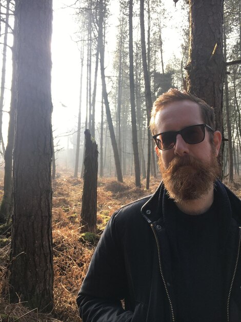 Premium Photo Portrait Of Bearded Man Wearing Sunglasses In Forest