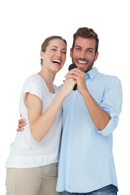 Premium Photo Portrait Of Cheerful Couple Singing Into Microphone