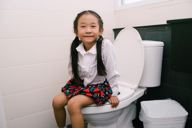Premium Photo Portrait Of Cute Smiling Girl Sitting On Toilet Bowl In