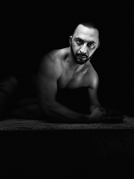 Premium Photo Portrait Of Shirtless Man Sitting Over Black Background