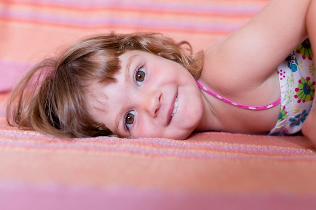 Premium Photo Portrait Of Smiling Cute Girl Lying On Sofa