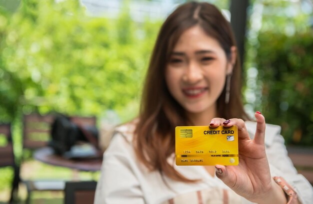Premium Photo | Portrait of smiling young woman holding credit card Premium Photo | Portrait of smiling young woman holding credit card