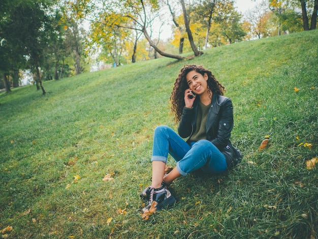 Premium Photo Portrait Of A Smiling Young Woman Sitting On Grass