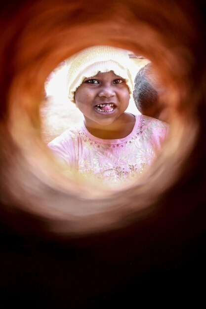 Premium Photo Portrait Of Woman Sticking Out Tongue Seen Through Hole