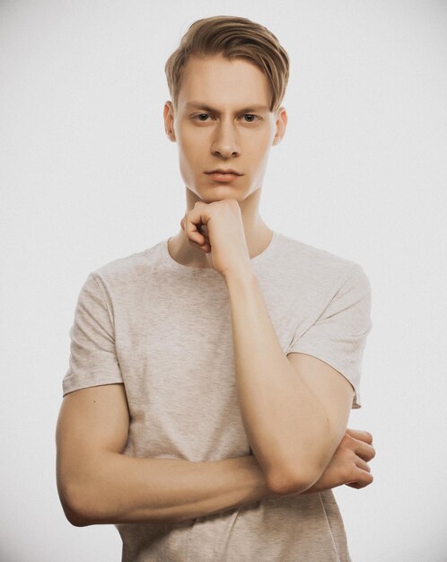 Premium Photo | Portrait of the young thinking man with hand near face Premium Photo | Portrait of the young thinking man with hand near face