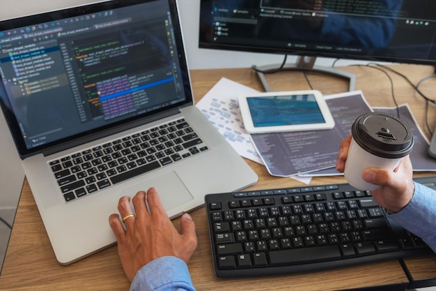 Premium Photo | Programmer drinking coffee while using laptop on table Premium Photo | Programmer drinking coffee while using laptop on table