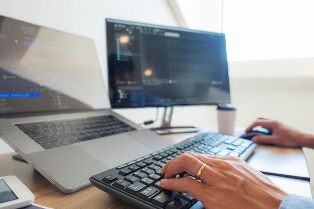 Premium Photo | Programmer using laptop and computer on table Premium Photo | Programmer using laptop and computer on table