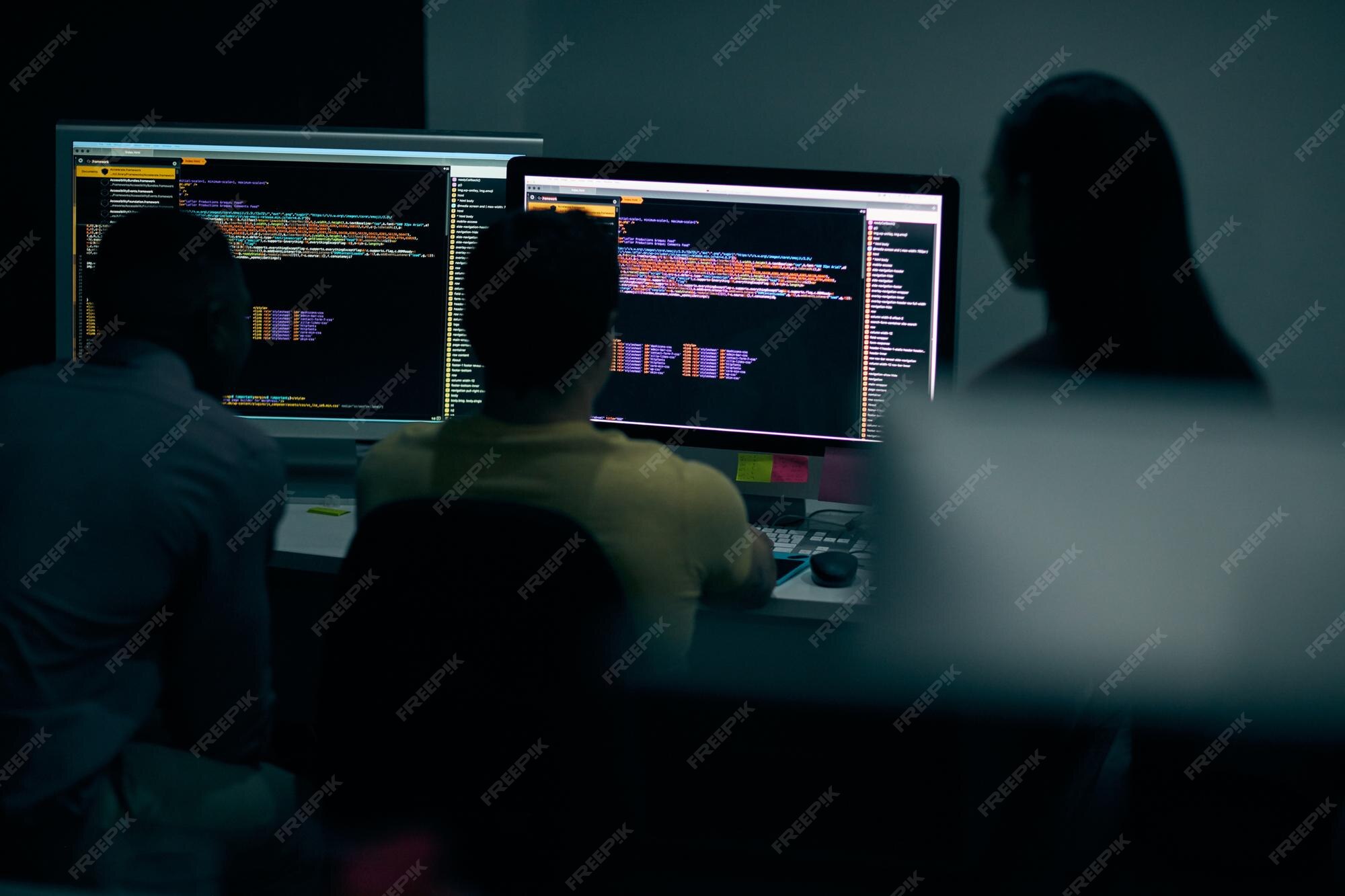 Premium Photo | Programming code and computer with business people in office at night for cyber ...