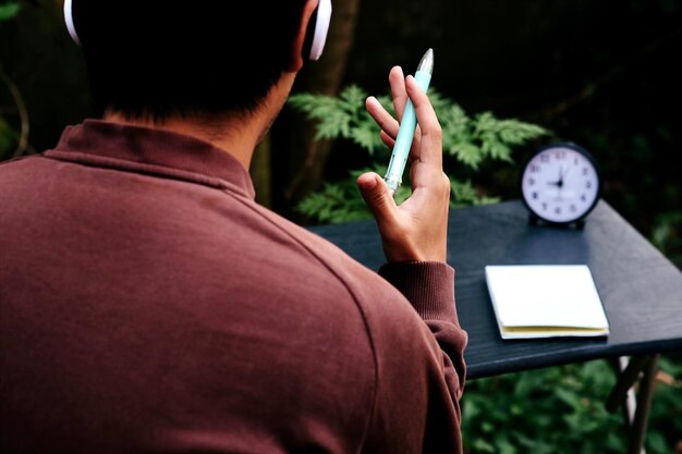 Premium Photo | Rear view of man holding pen Premium Photo | Rear view of man holding pen