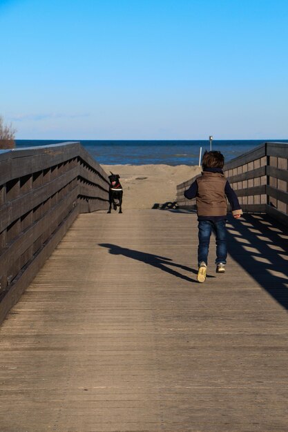 Premium Photo | Rear view of people standing on pier Premium Photo | Rear view of people standing on pier