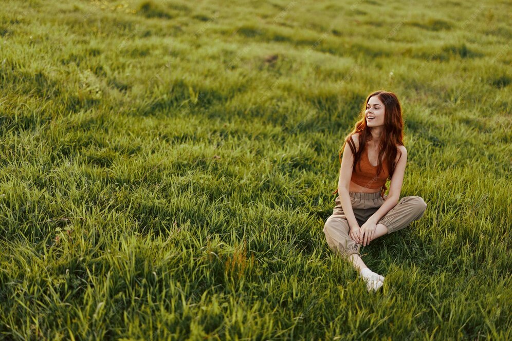 Premium Photo A Redhaired Woman Sits In Nature On The Grass With Her