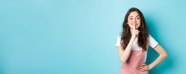 Premium Photo Shh Be Quiet Cute Brunette Girl Shushing And Smiling