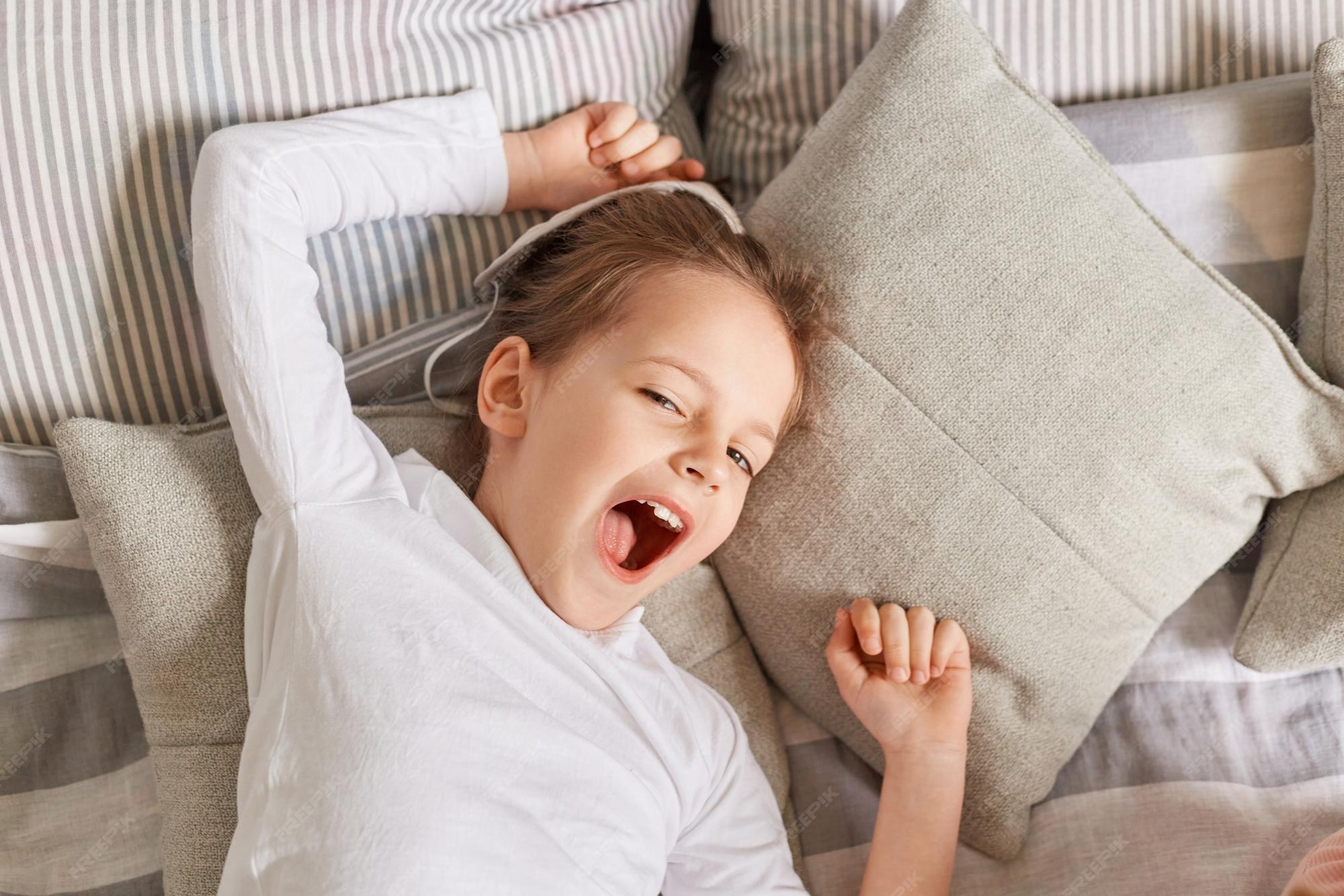 Premium Photo | Sleepy little girl yawning in the morning while lying ... Premium Photo | Sleepy little girl yawning in the morning while lying ...