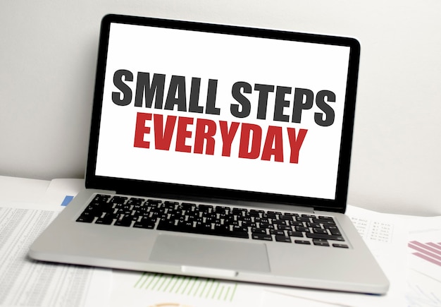 Premium Photo | Small steps everyday word on laptop with charts Premium Photo | Small steps everyday word on laptop with charts