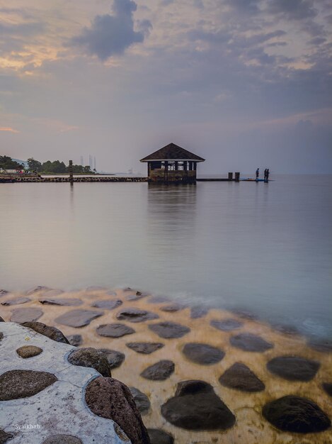 Premium Photo | A small wooden structure sits on the shore of lake bohol. Premium Photo | A small wooden structure sits on the shore of lake bohol.