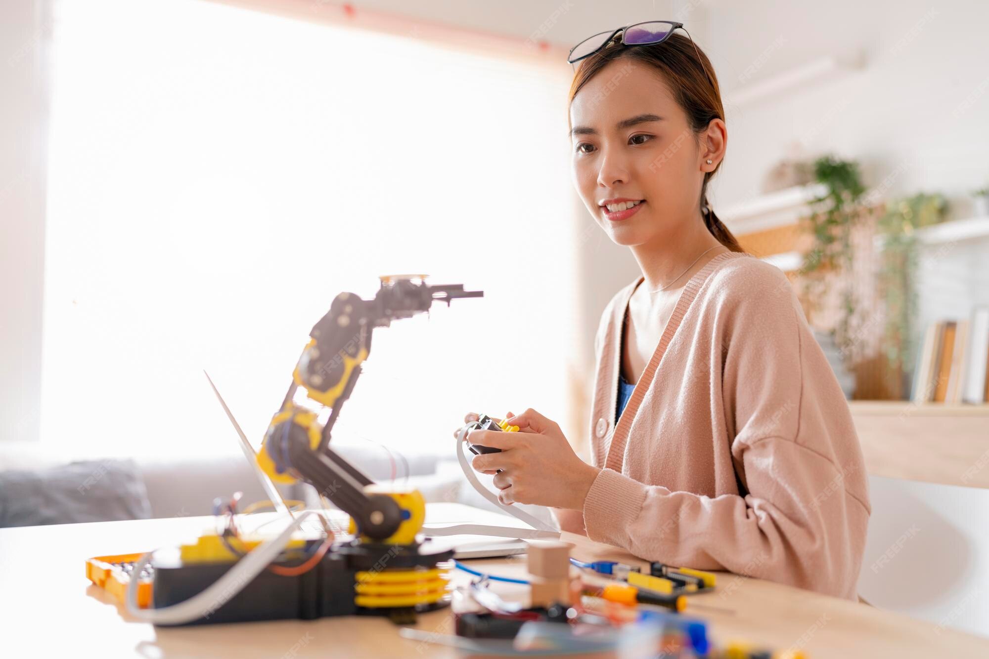 Premium Photo | Smart asian female programer learning robot arm ai coding electronic board cable ...