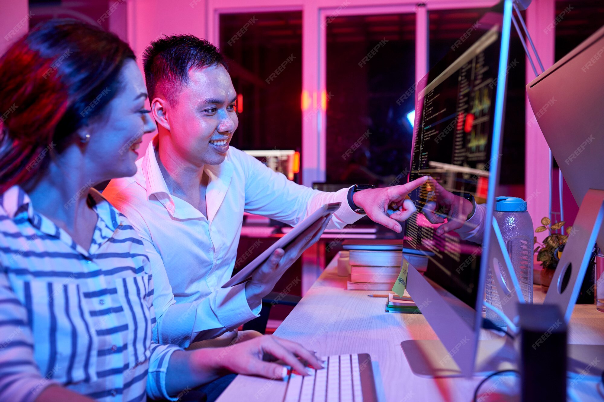 Premium Photo | Smiling software developers discussing programming code ...