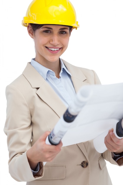 Premium Photo | Smiling young architect holding plan Premium Photo | Smiling young architect holding plan