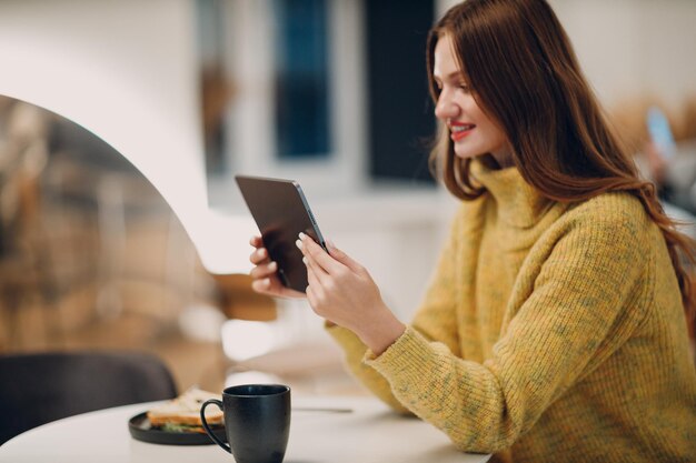 Premium Photo | Smiling young woman using digital tablet Premium Photo | Smiling young woman using digital tablet