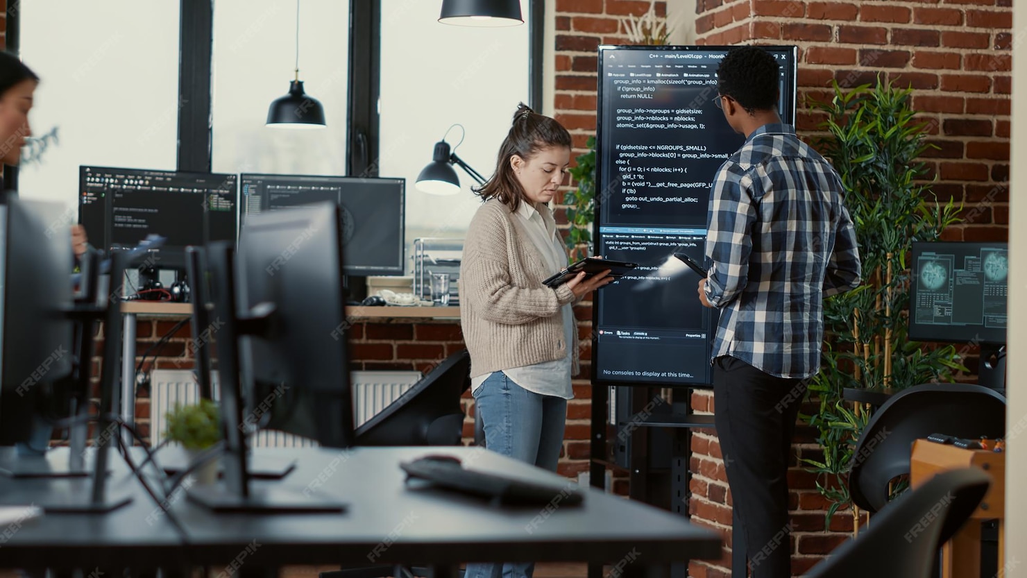 Premium Photo | Software developer holding digital tablet analyzing code on wall screen tv ...