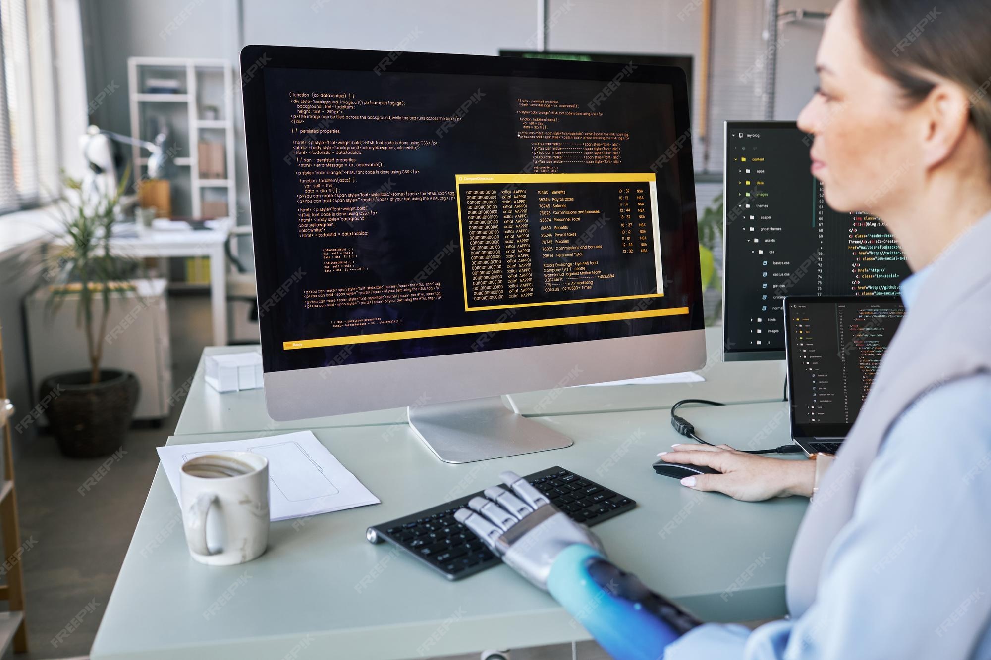 Premium Photo | Software developer with prosthetic arm checking programming code on computer screen