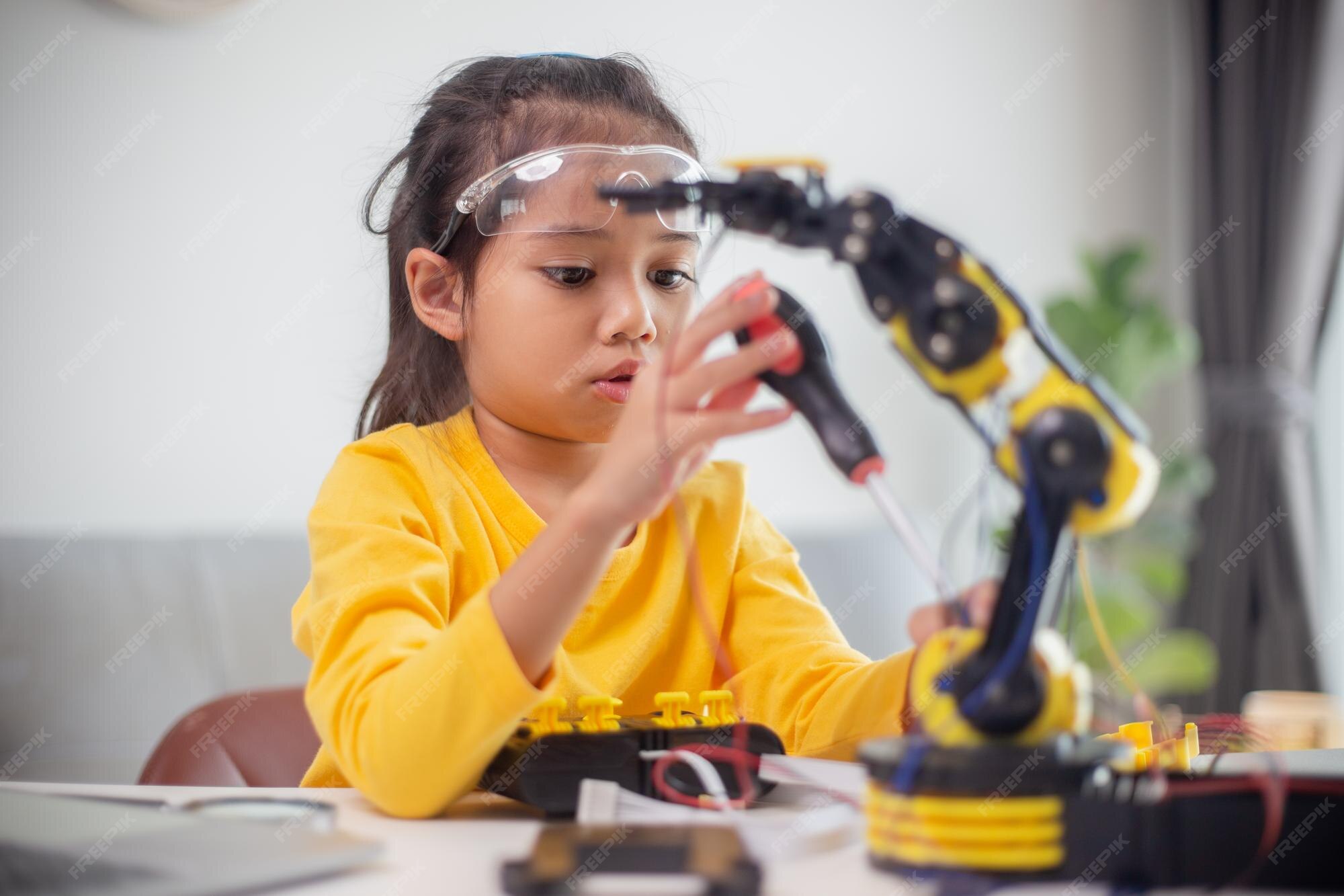 Stem 교육 개념 아시아 학생들은 로봇 팔을 Stem 수학 공학 과학 기술 컴퓨터 코드로 아이들의 개념을 로봇 공학으로 코딩하여 집에서 배웁니다 프리미엄 사진