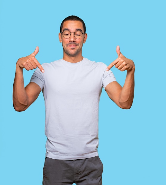 Premium Photo | Surprised young man pointing down Premium Photo | Surprised young man pointing down