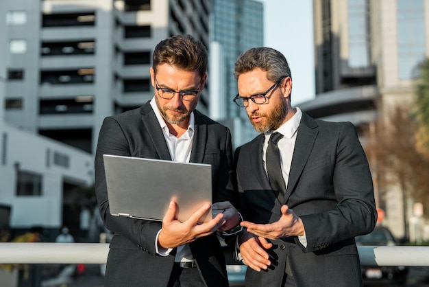 Premium Photo | Two handsome young businessmen in classic suits using ... Premium Photo | Two handsome young businessmen in classic suits using ...