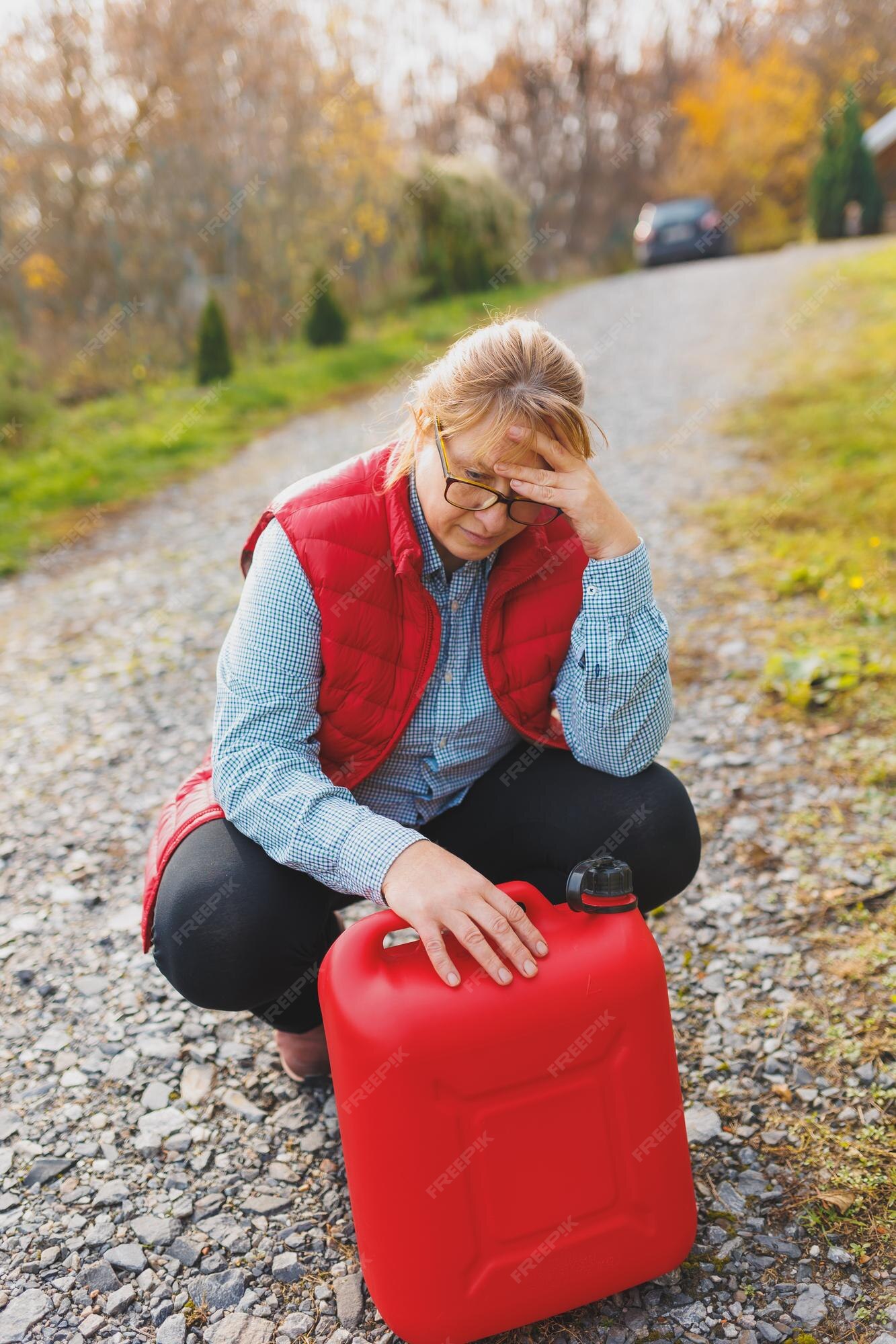 Premium Photo White Woman In Red Vest Holding Red Gasoline Container And Posing On Scenic