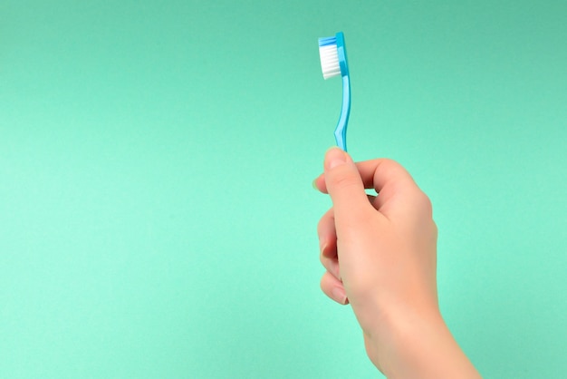Premium Photo The Woman Holds Toothbrushes In Her Hand On A Green