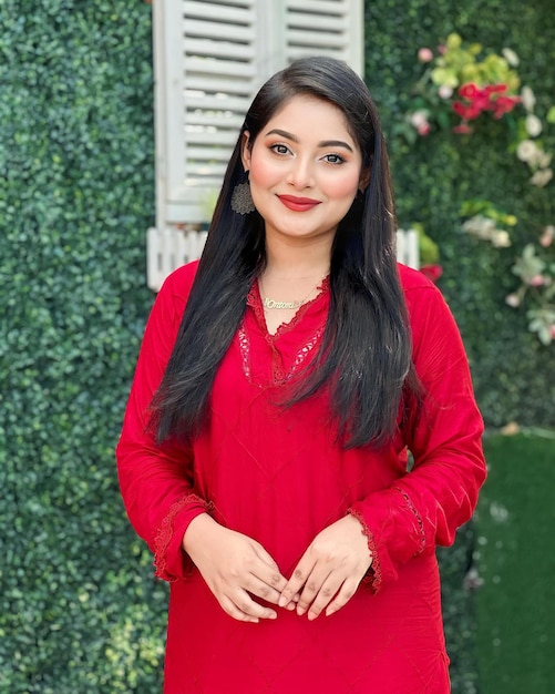 Premium Photo A Woman In A Red Dress Stands In Front Of A Green Wall
