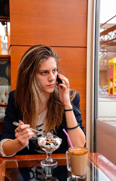 Premium Photo Woman Using Smart Phone While Sitting At Table In Cafe