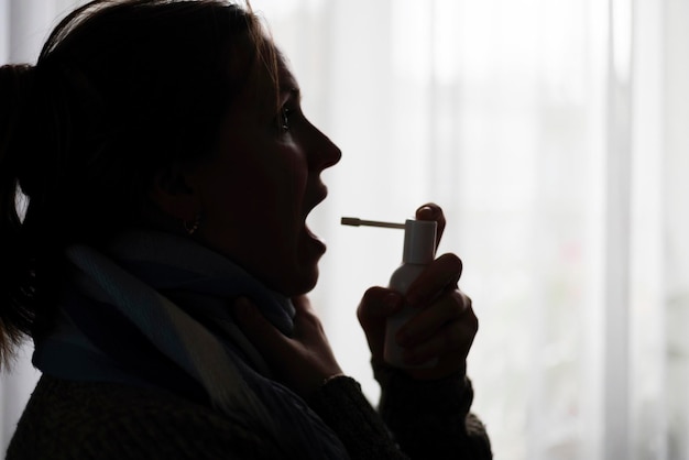 Premium Photo A Woman With A Sore Throat Sprays A Medicinal Aerosol
