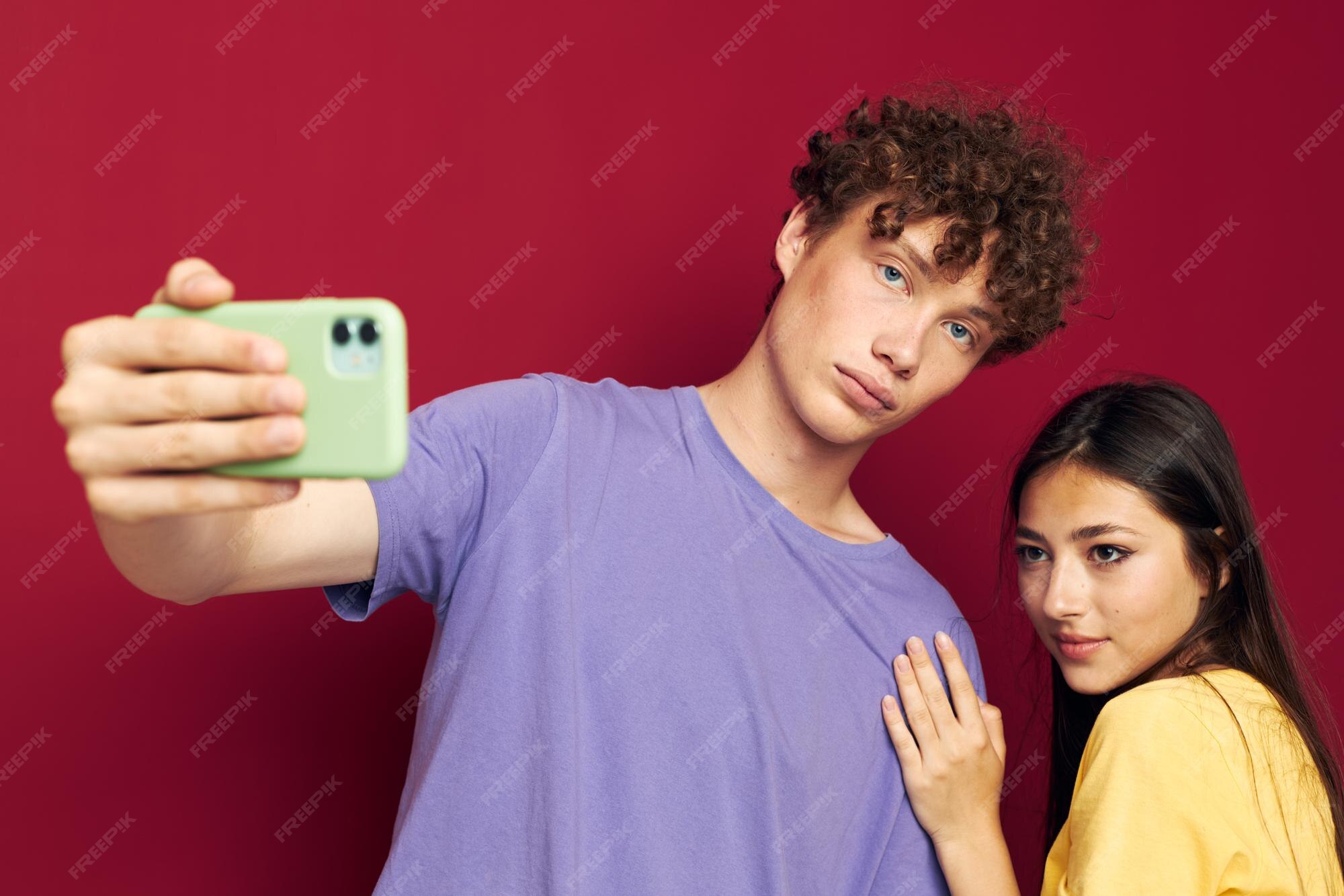 Premium Photo A Young Couple Take A Selfie Posing Hug Isolated Background