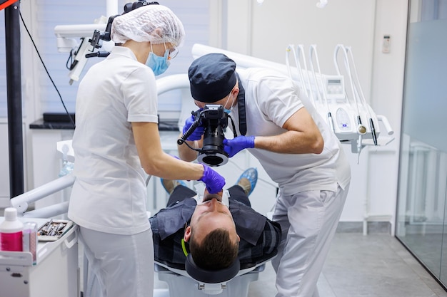 Premium Photo A Young Dentist Takes A Picture Of The Patients Teeth
