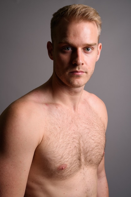 Premium Photo Young Handsome Man With Blond Hair Shirtless Against Gray
