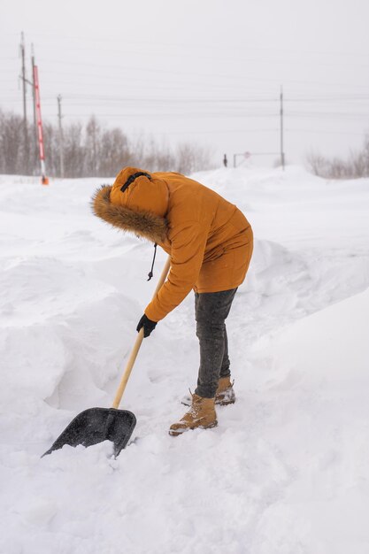 Premium Photo | Young man clearing snow in his backyard village house ... Premium Photo | Young man clearing snow in his backyard village house ...