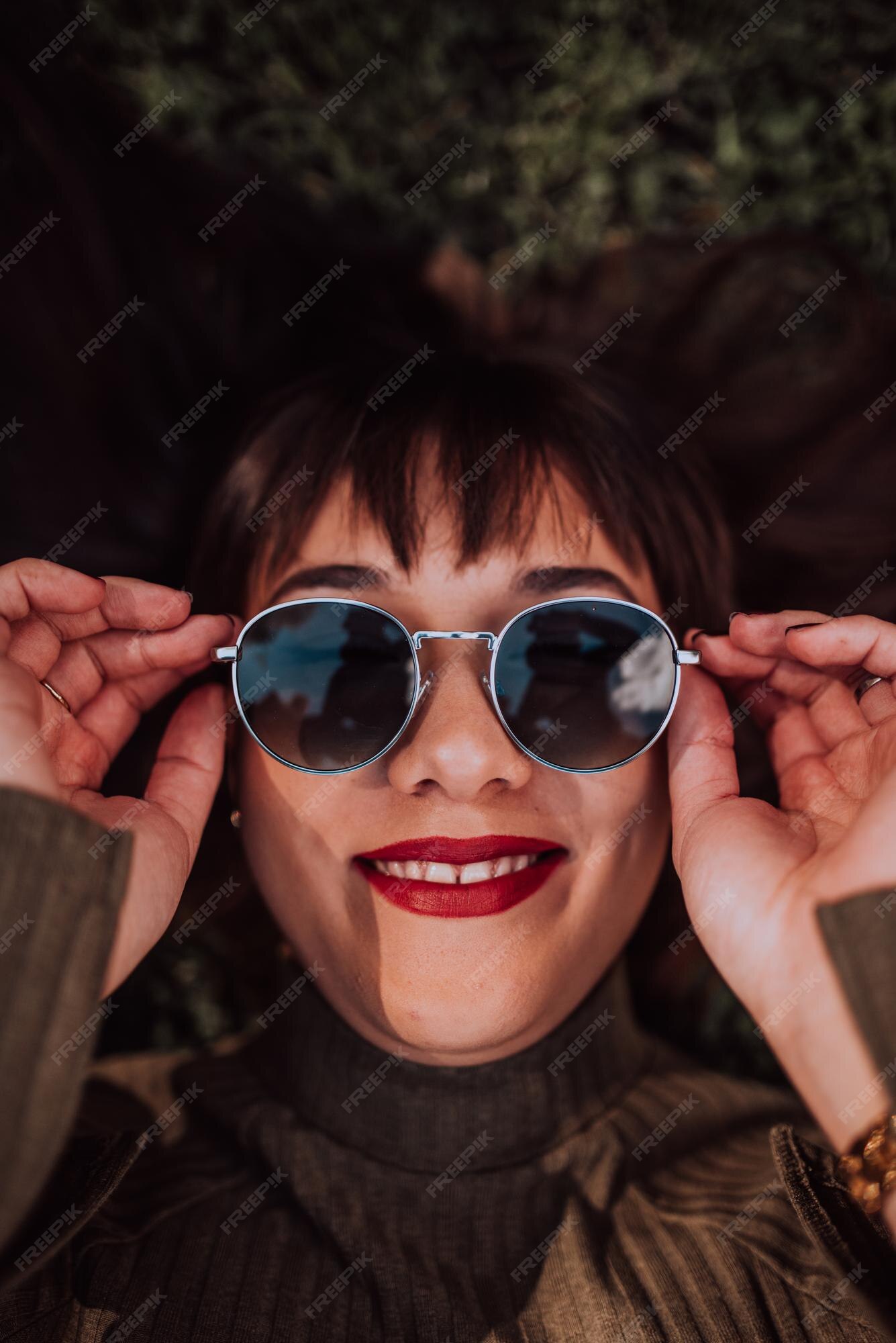 Premium Photo A Young Woman With Sunglasses Lying On The Grass